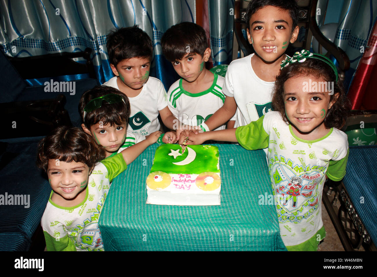 children wearing green and white colors dress and held in hands ...