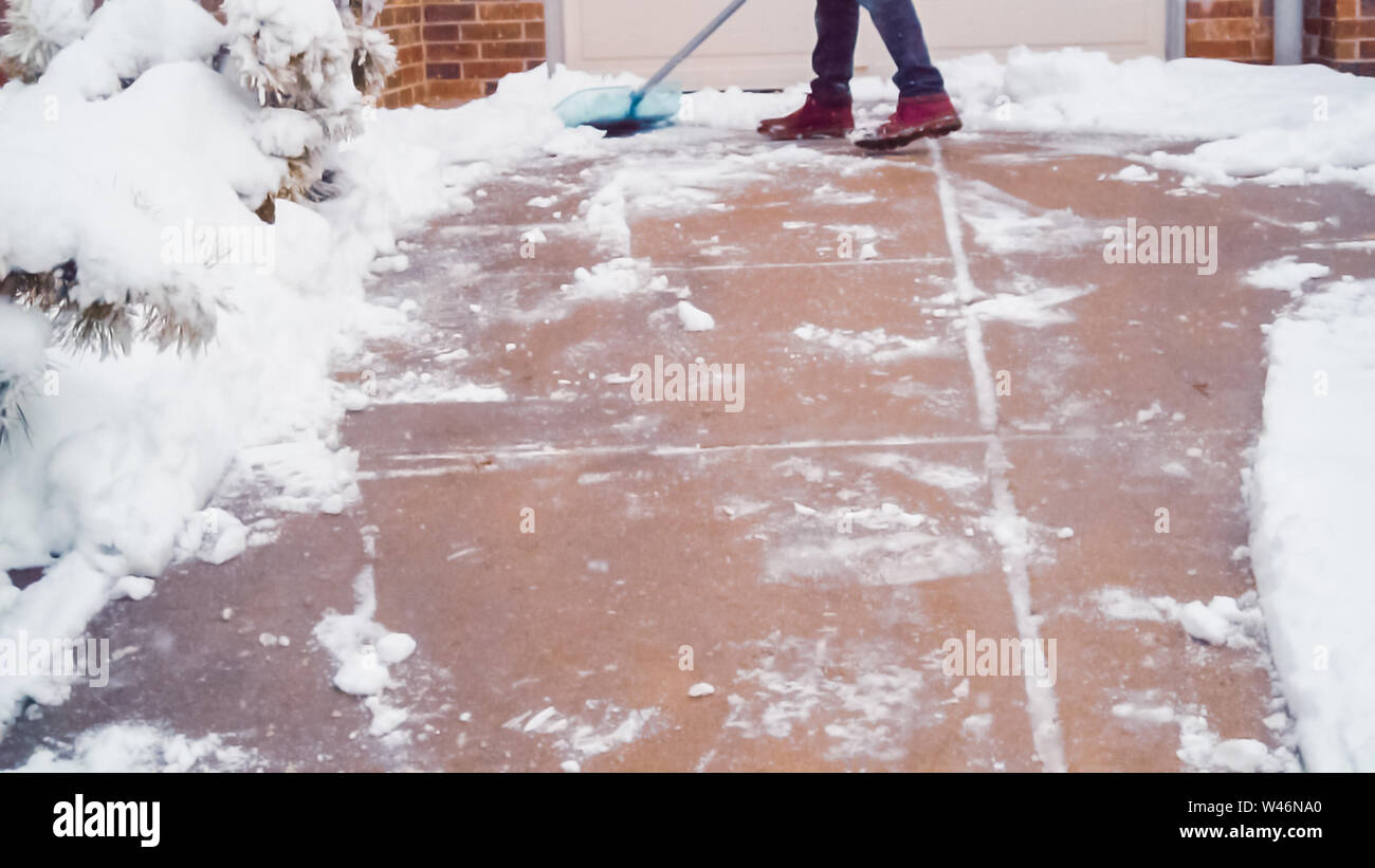 Young man shoveling snow from driveway Stock Photo - Alamy