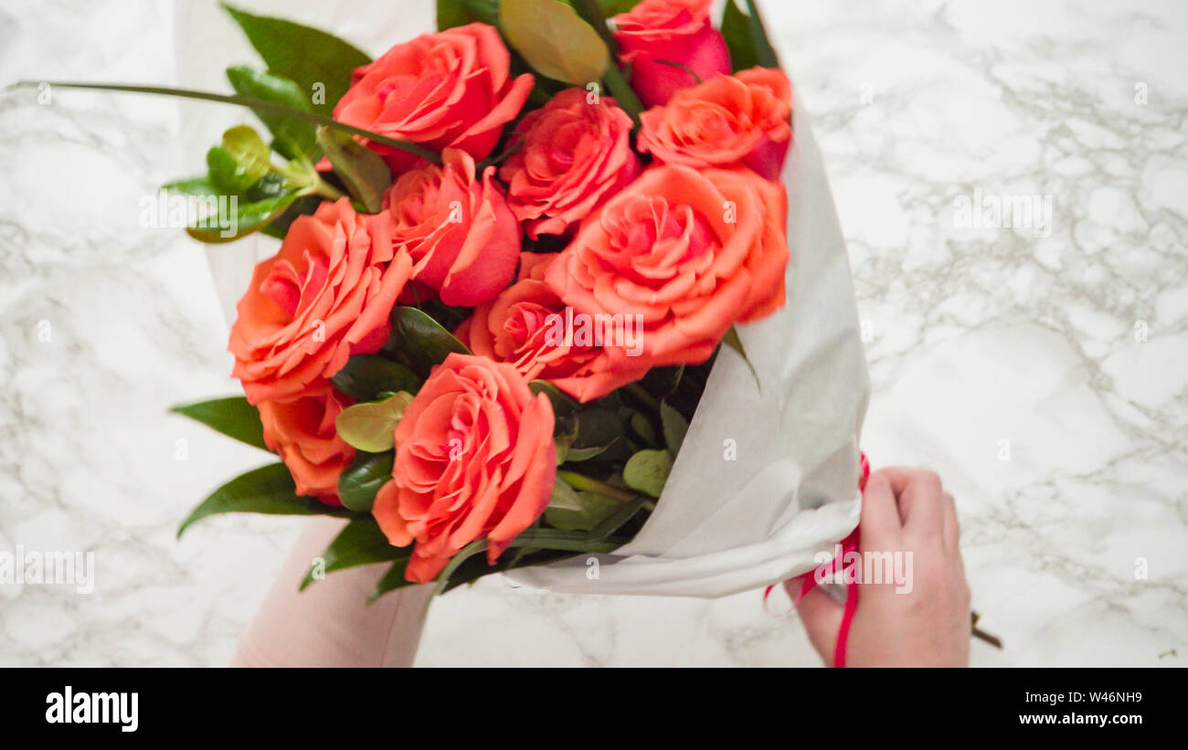 Flat lay. Florist wrapping red roses into a beautiful bouquet Stock ...