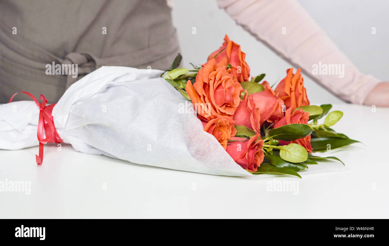 Florist wrapping red roses into a beautiful bouquet Stock Photo - Alamy