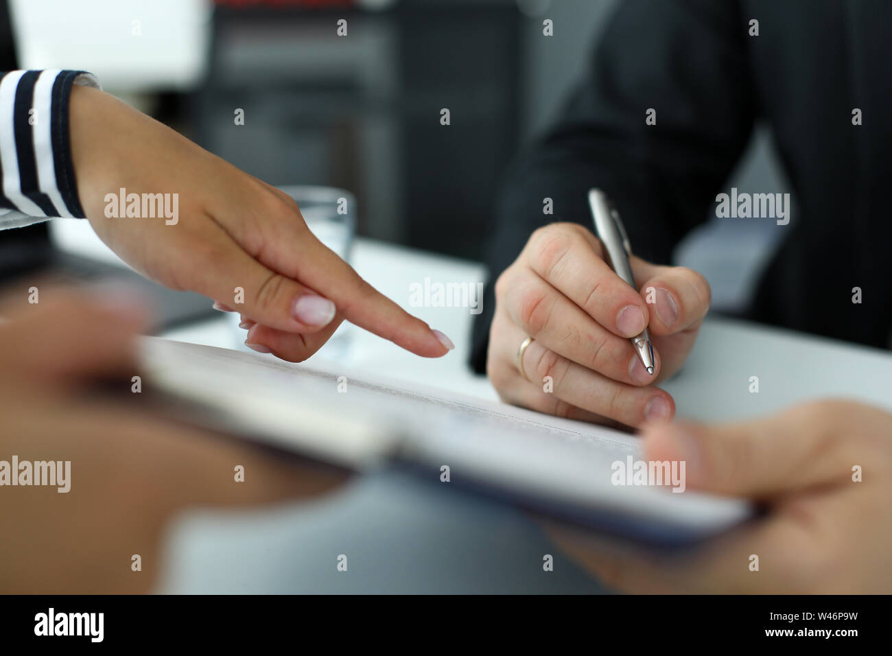 Real estate clerk pointing where visitor should sign document Stock ...