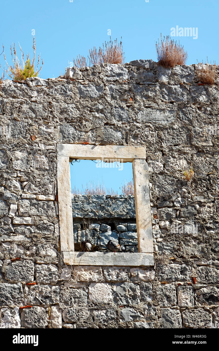 partially crumbling stone fortress wall; 15th century; window framing ...