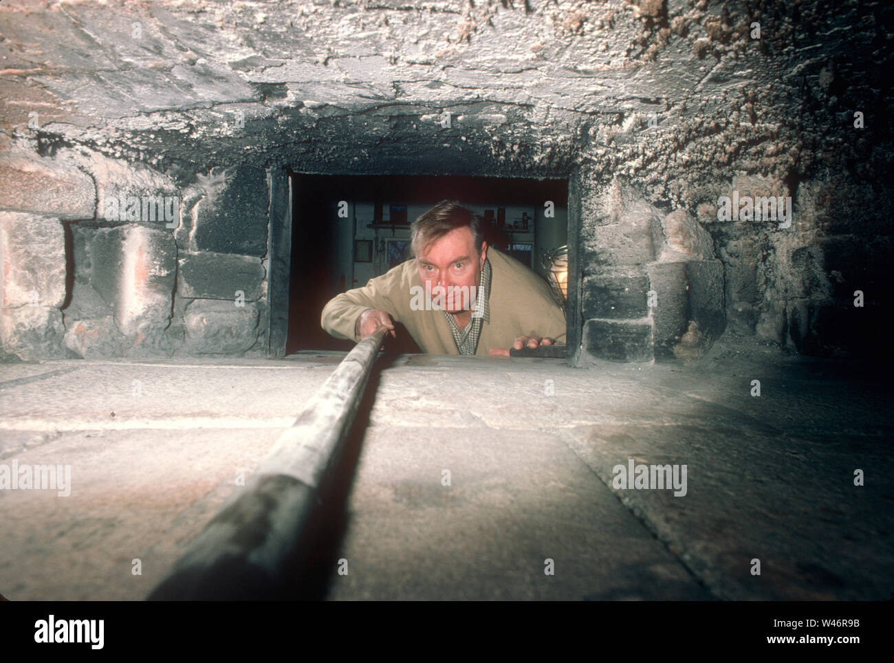 Stan Kew loading the bread oven in the traditional village bakery ...