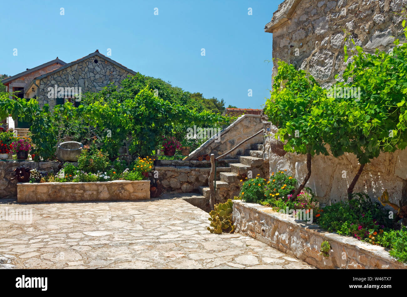 old stone houses; traditional hamlet; courtyard, planters, flowers ...