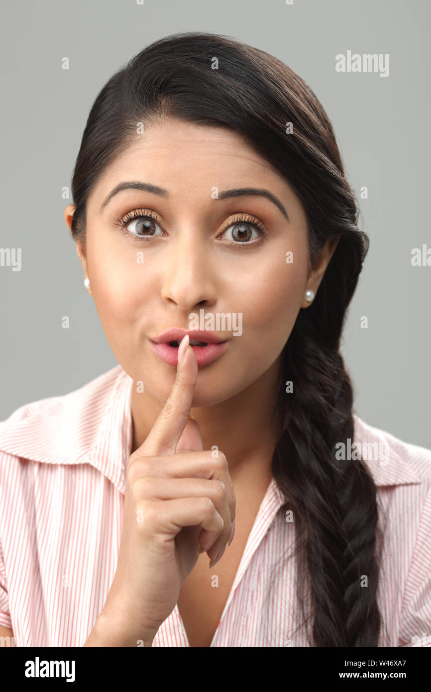 Portrait of a woman with a finger on lips Stock Photo - Alamy