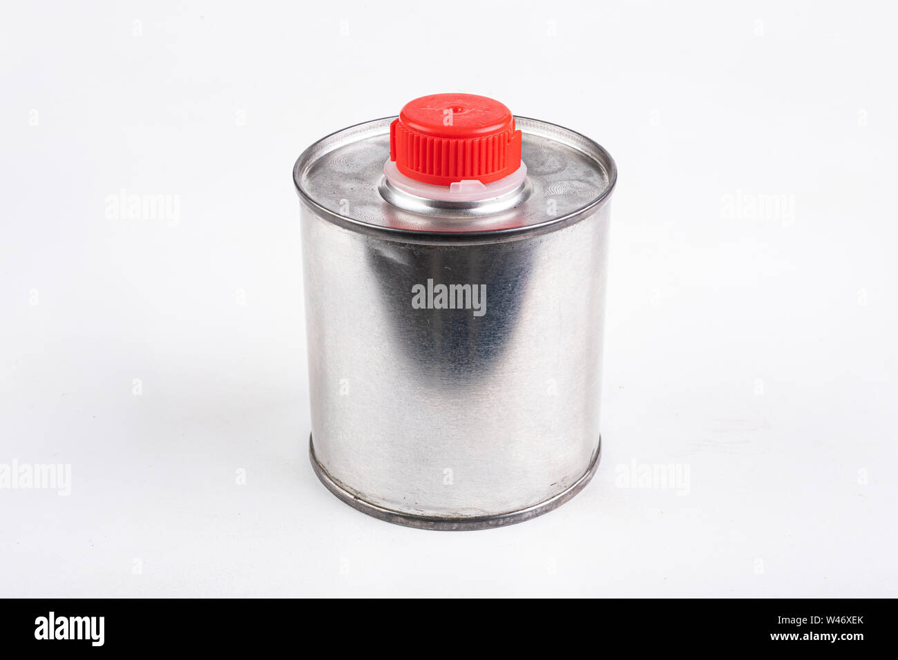 Metal container for chemicals on a white table. A tin plate with a ...
