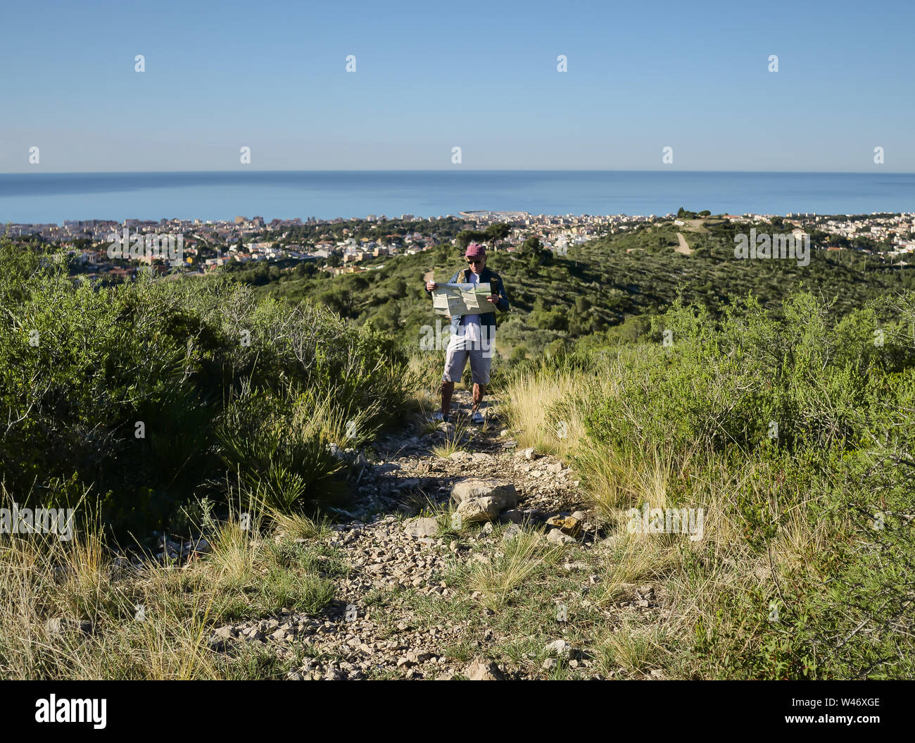 Young male tourist with a map of the area stands on a stone path Stock ...