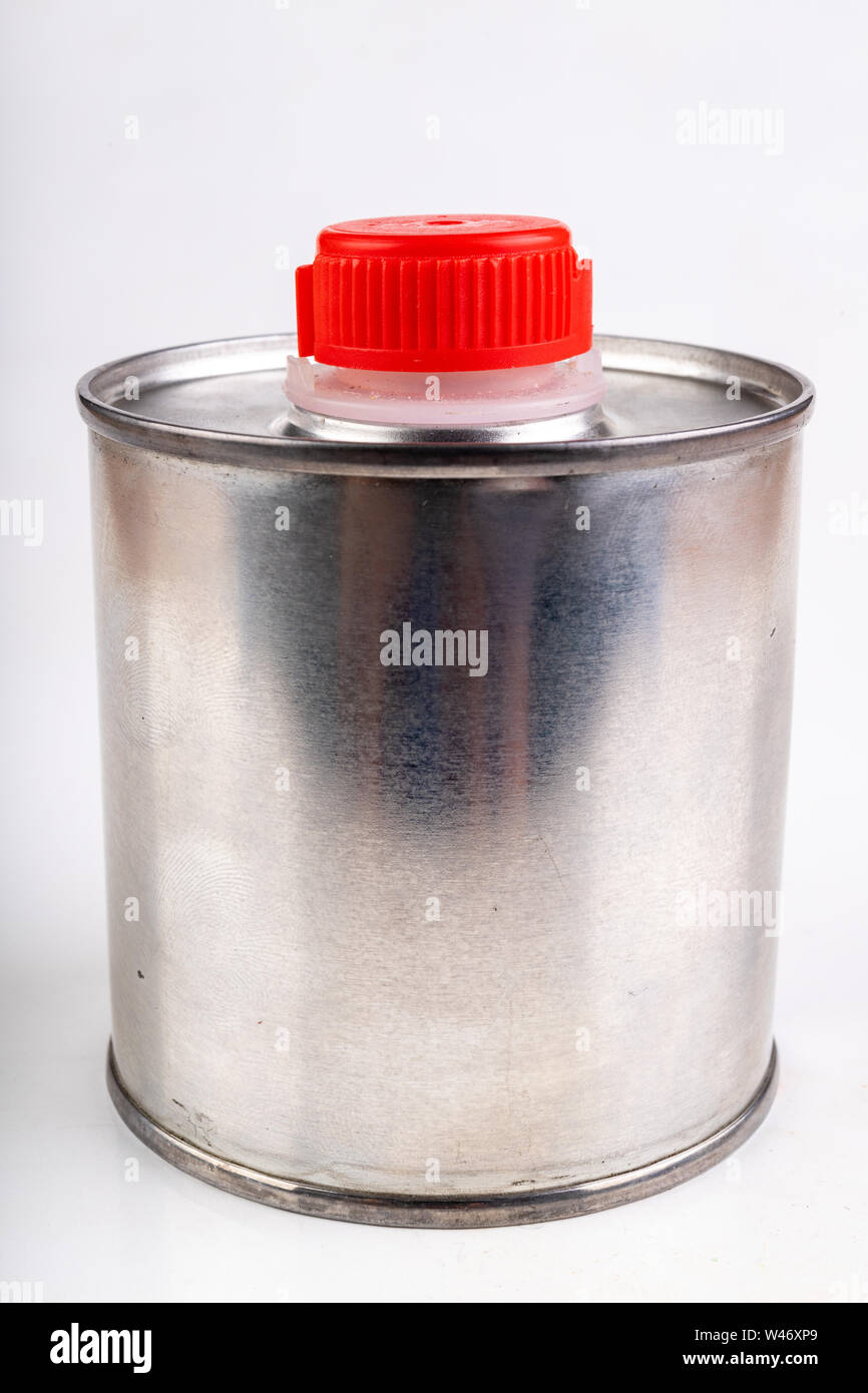 Metal container for chemicals on a white table. A tin plate with a ...