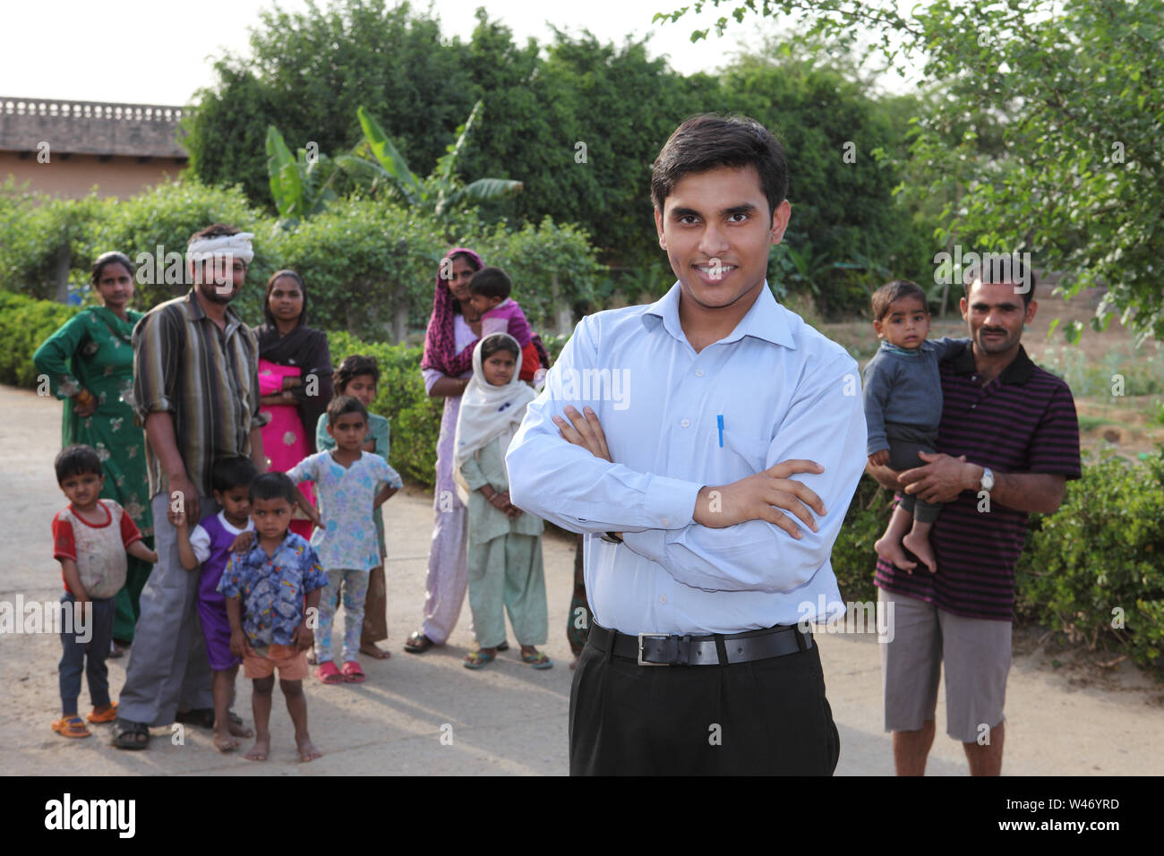 Portrait of a man smiling with villagers standing behind him Stock ...