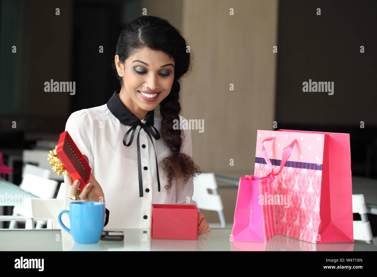 Woman opening a gift box and smiling Stock Photo - Alamy