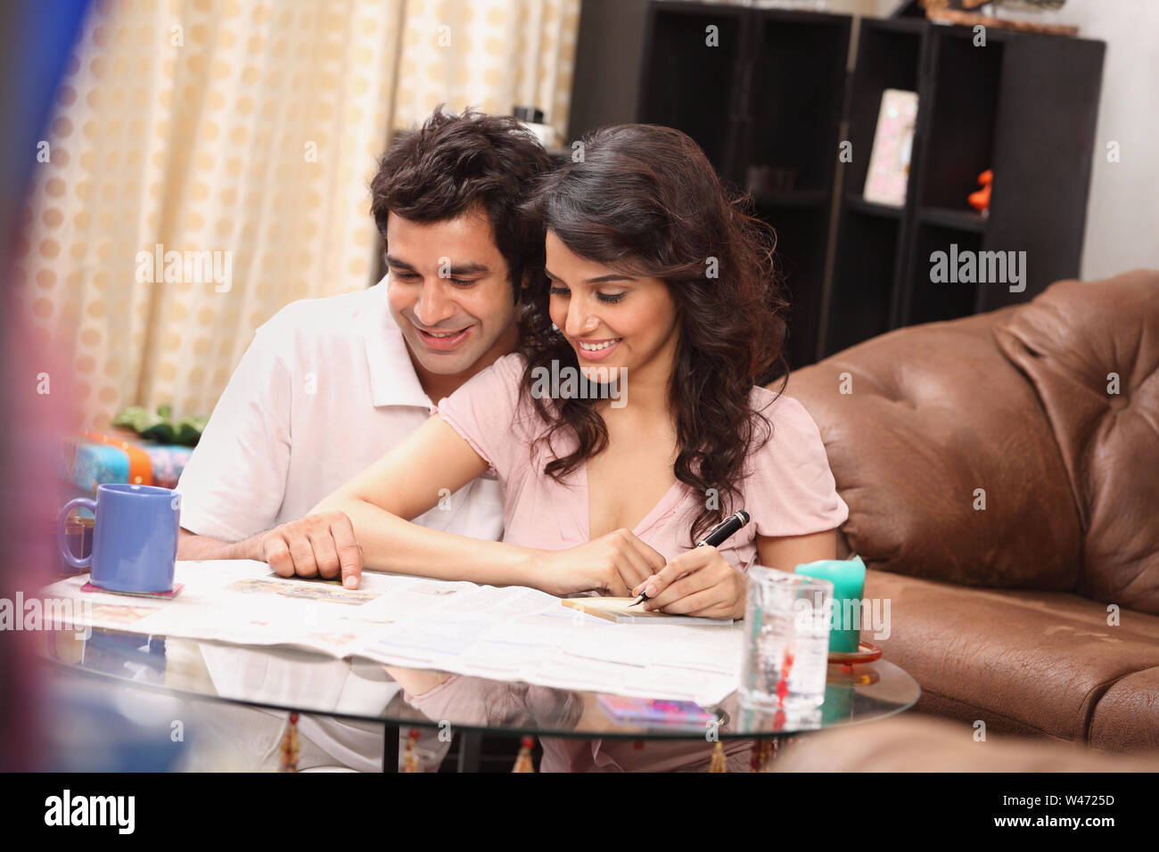 Couple searching advertisement for holidays Stock Photo - Alamy