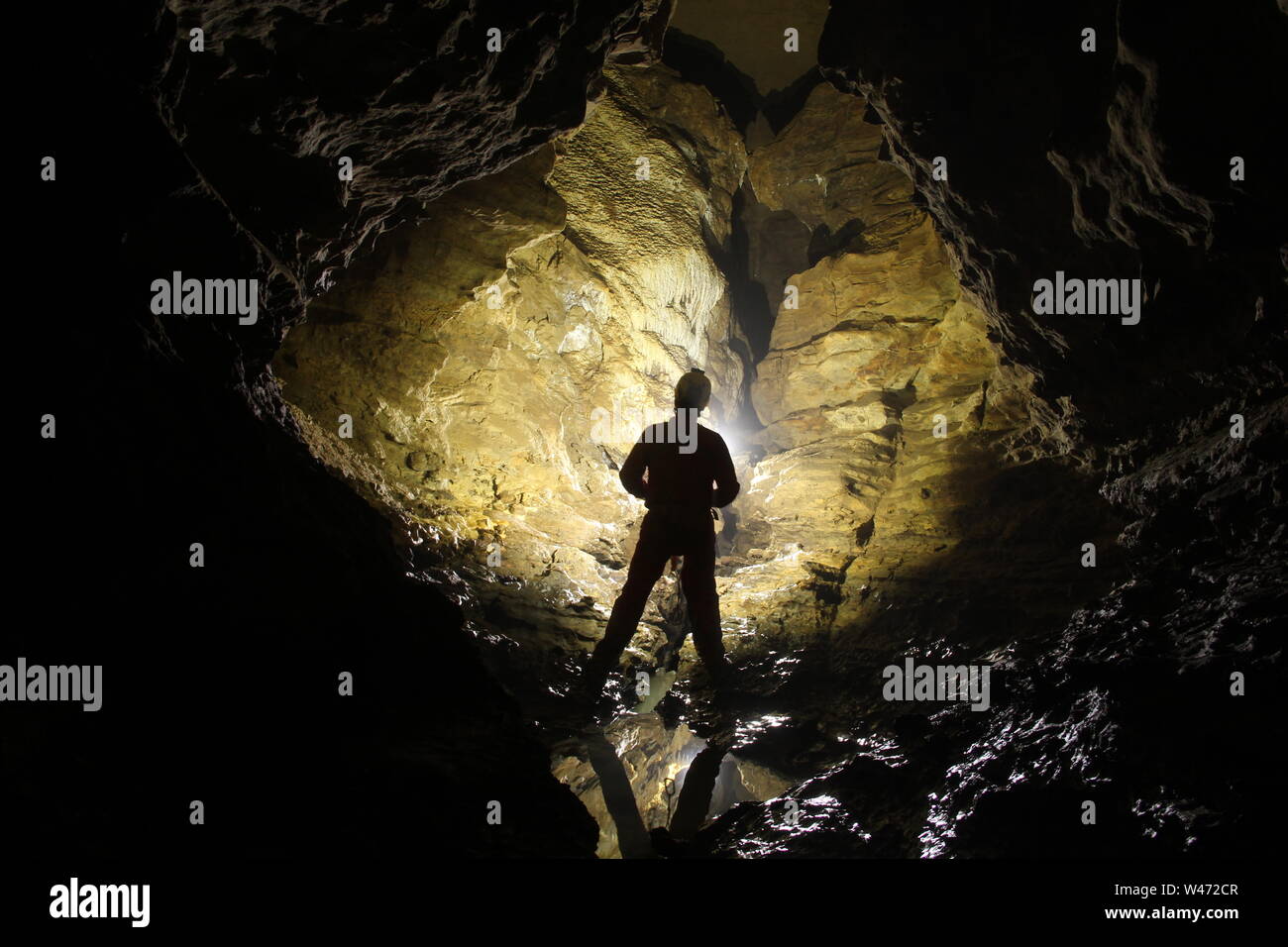 Caver exploring a cave Stock Photo - Alamy