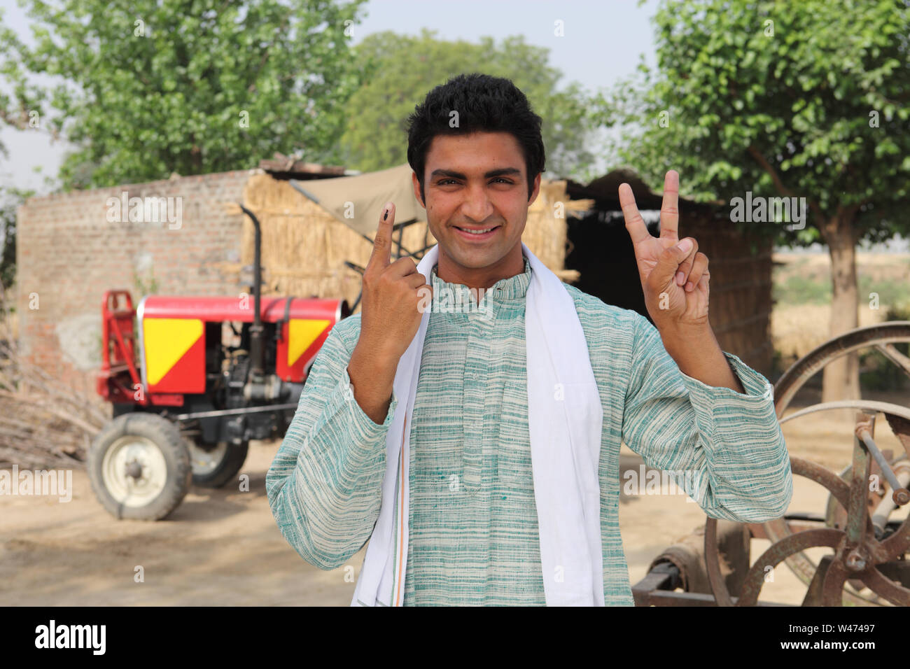Farmer pointing upward and showing V sign Stock Photo - Alamy