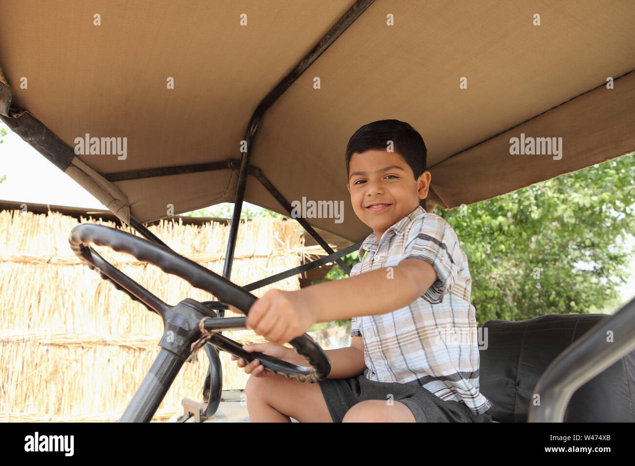 Boy driving a tractor Stock Photo - Alamy