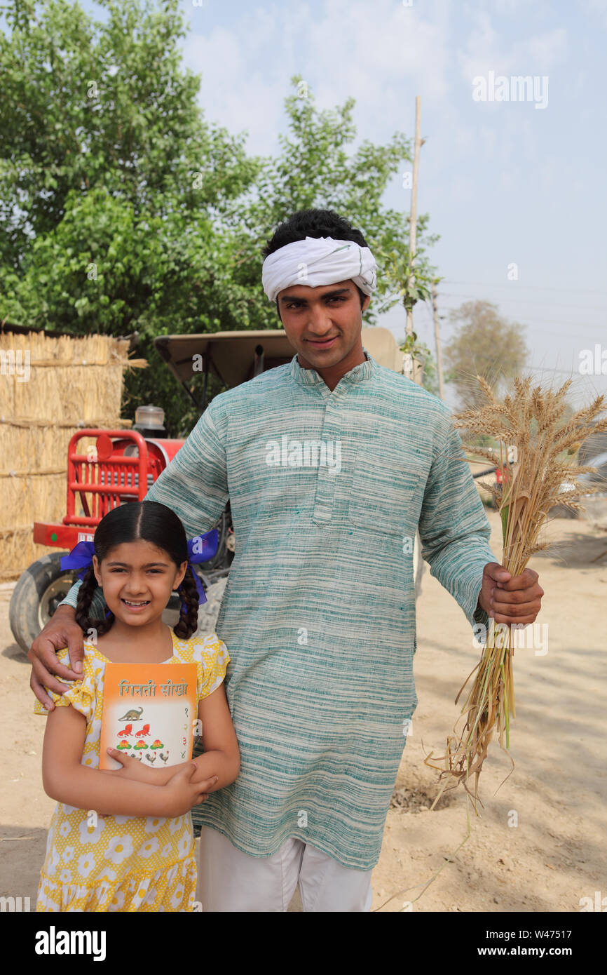 Farmer standing with his daughter Stock Photo - Alamy