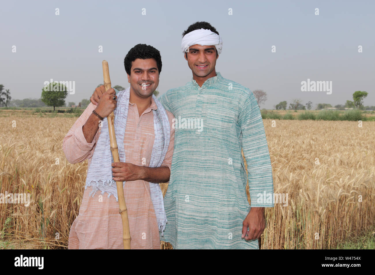Two farmers standing in a crop field Stock Photo - Alamy