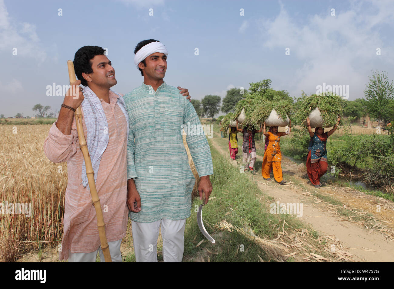 Two farmers standing in a crop field Stock Photo - Alamy