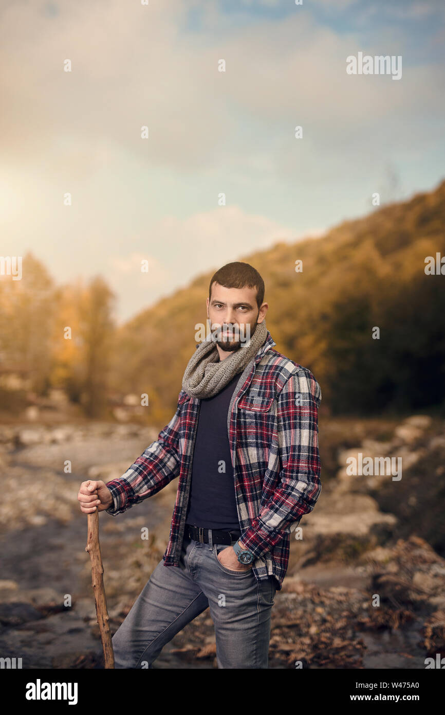handsome man in nature, holding wooden stick Stock Photo - Alamy