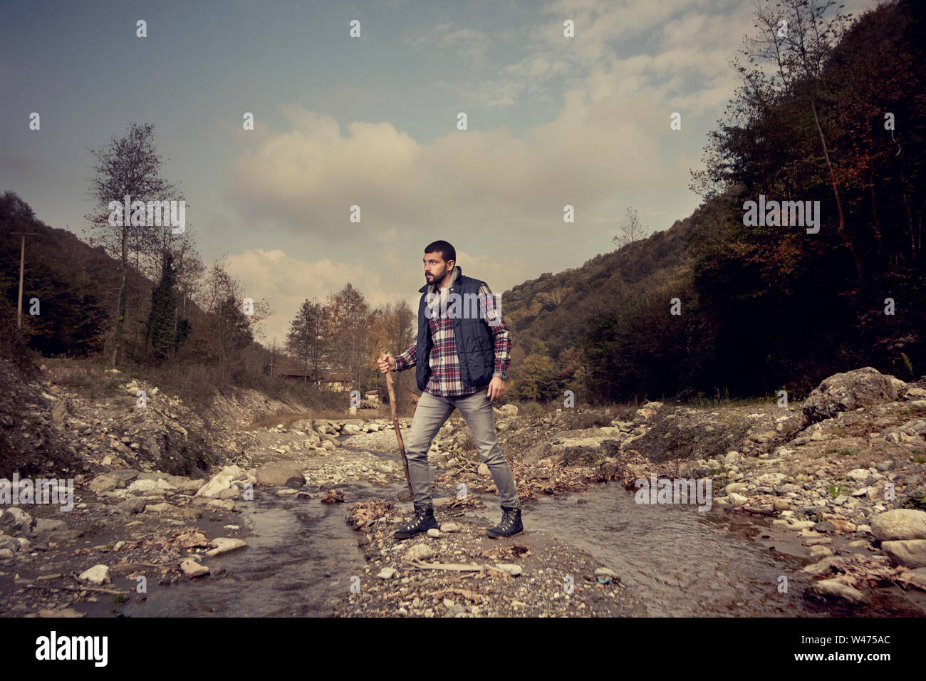 handsome man in nature, holding wooden stick Stock Photo - Alamy