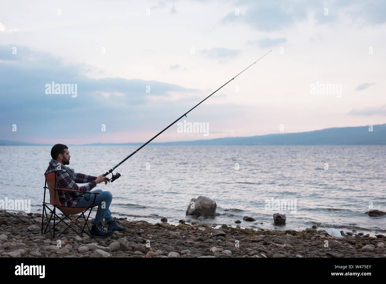 man in camp near lake, try to fishing Stock Photo - Alamy