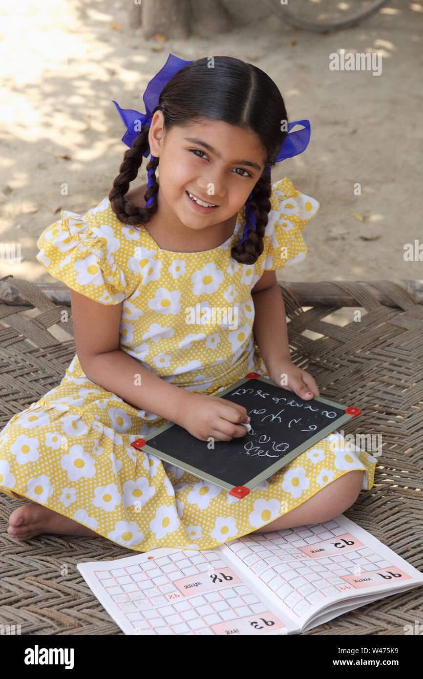 Girl writing numbers on a slate Stock Photo - Alamy