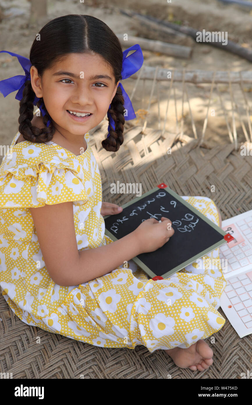 Girl writing numbers on a slate Stock Photo - Alamy