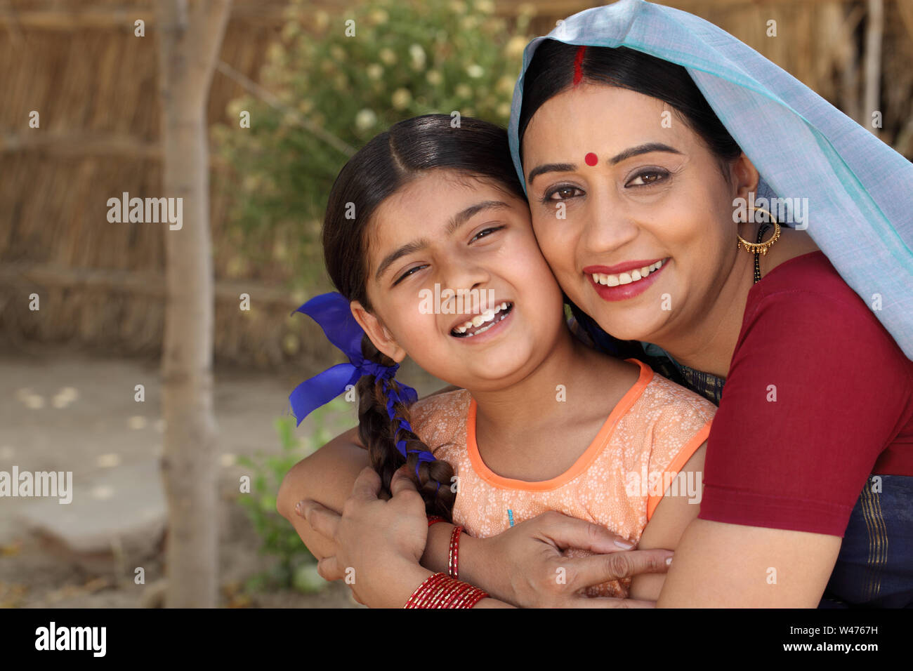 Indian woman hugging her daughter Stock Photo - Alamy
