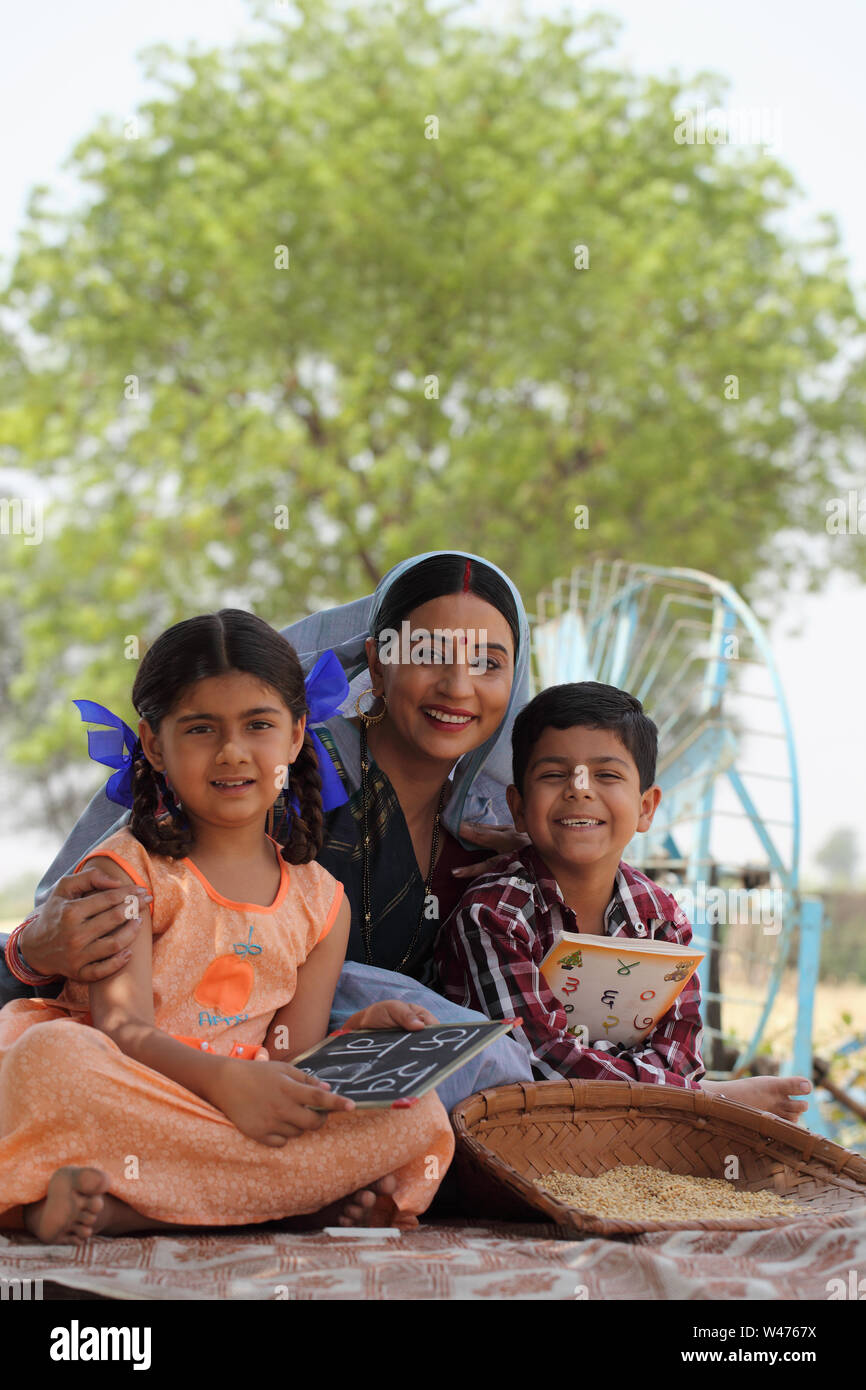 Woman with her two children sitting together Stock Photo - Alamy
