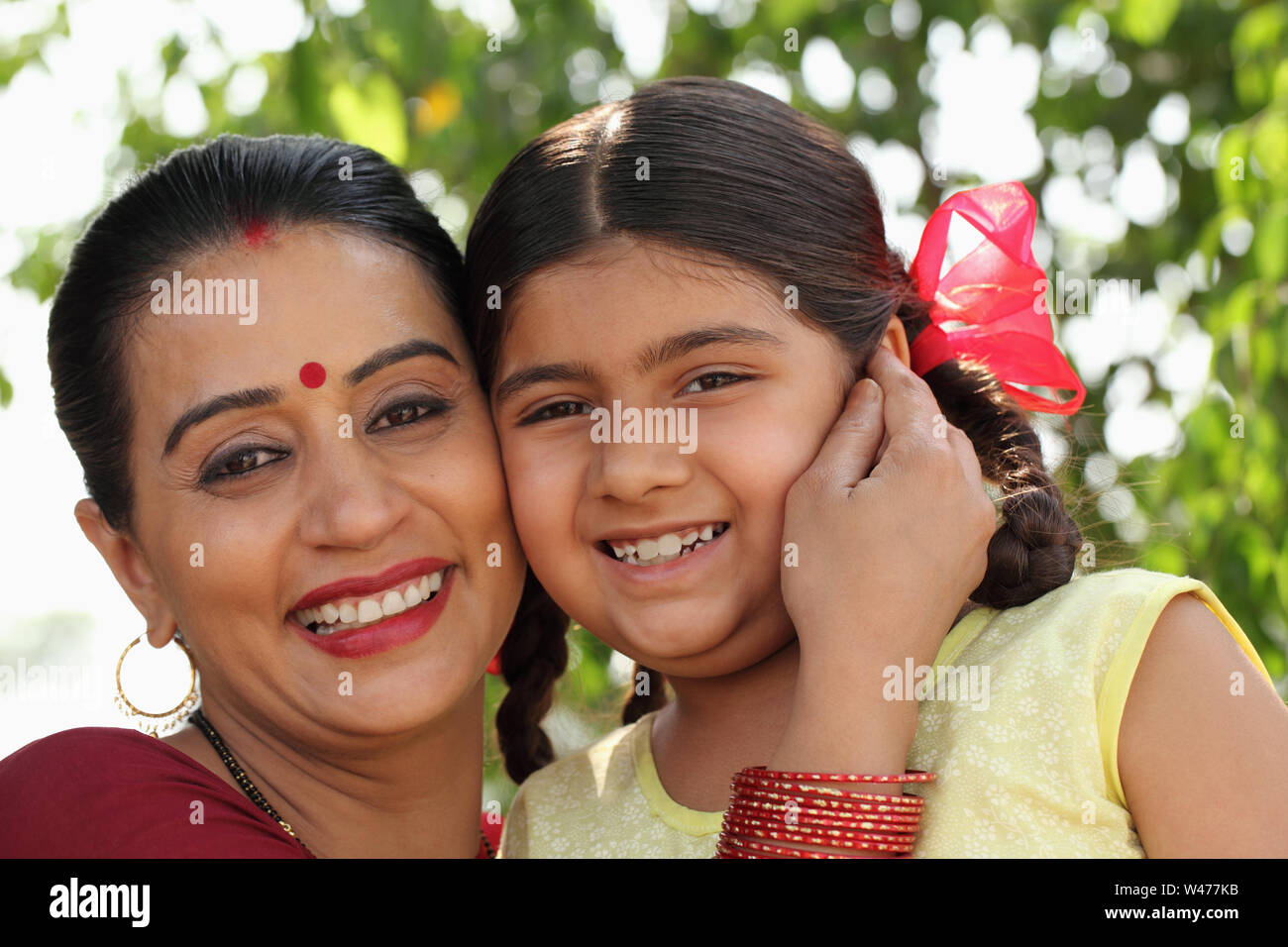 Portrait of a woman with her daughter smiling Stock Photo - Alamy