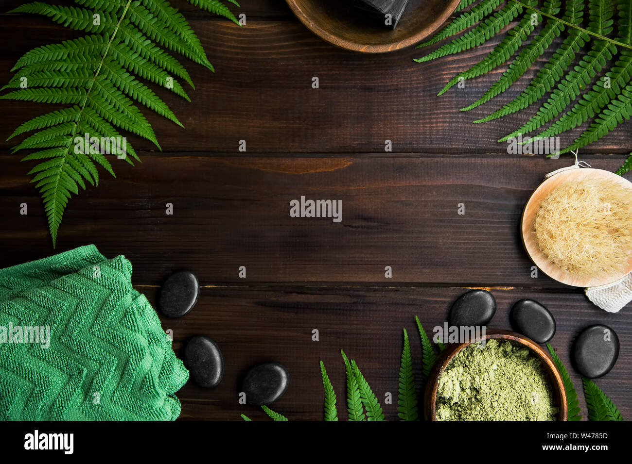 Green spa top view setting with fern leaves on wooden background with ...