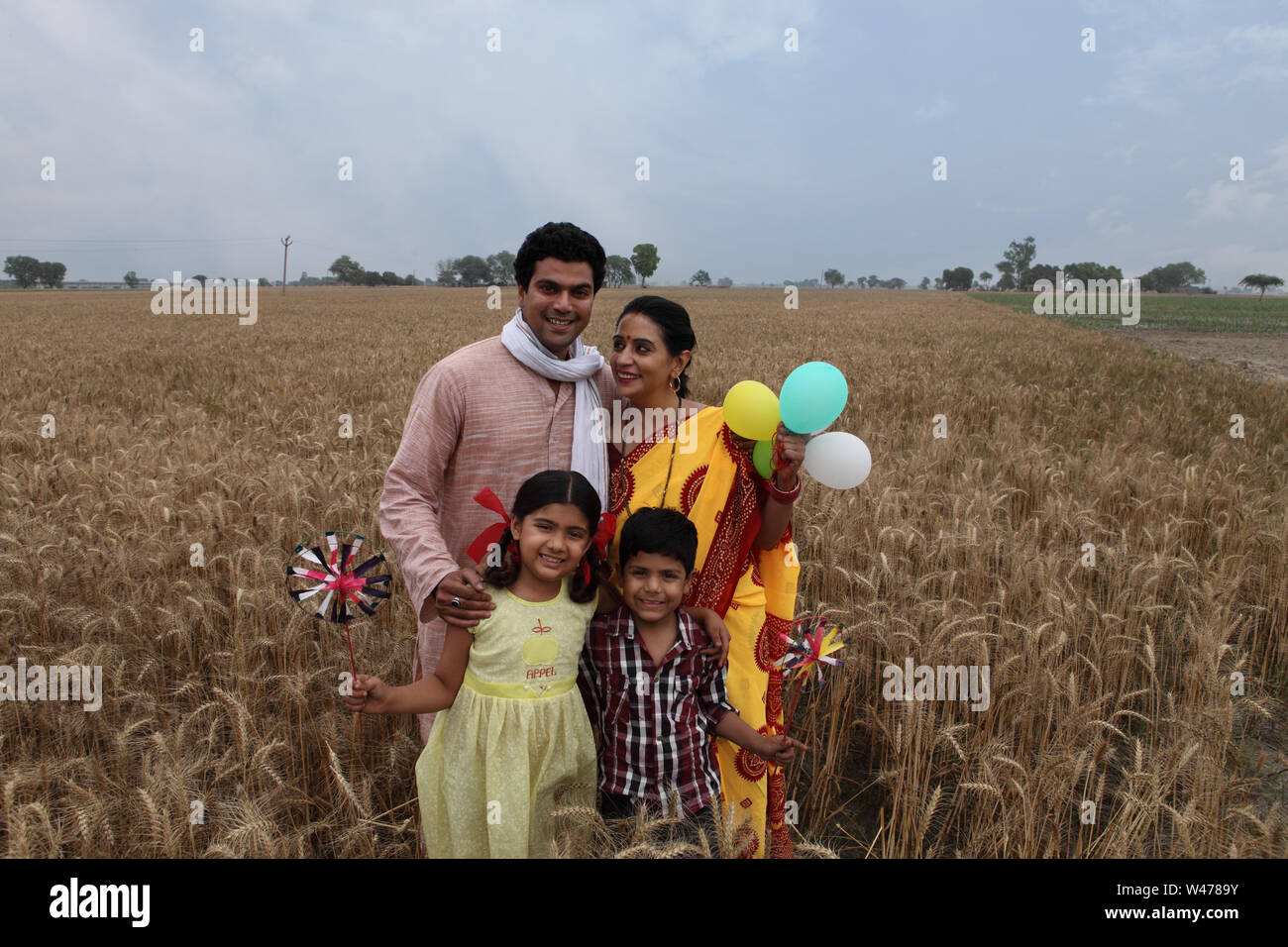 Indian rural family standing and smiling in a field Stock Photo - Alamy