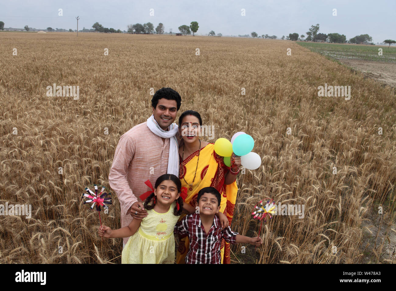 Rural family standing and smiling in a field Stock Photo - Alamy