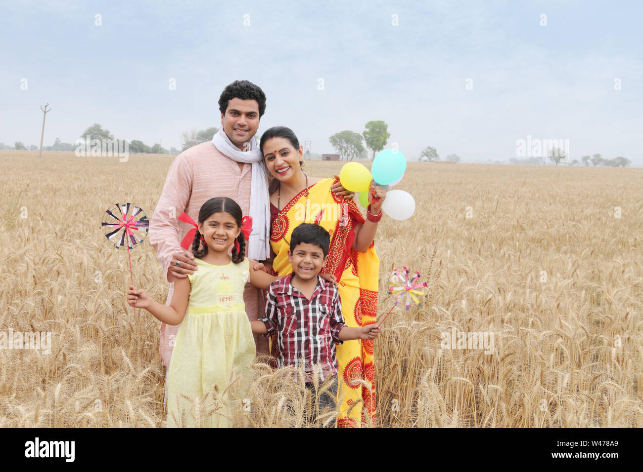 Rural family standing and smiling in a field Stock Photo - Alamy