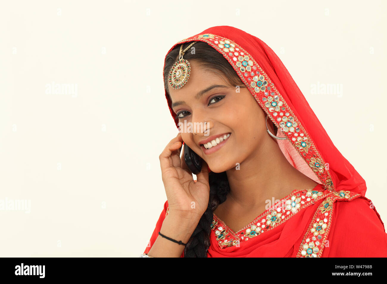 Indian woman talking on a mobile phone and smiling Stock Photo - Alamy
