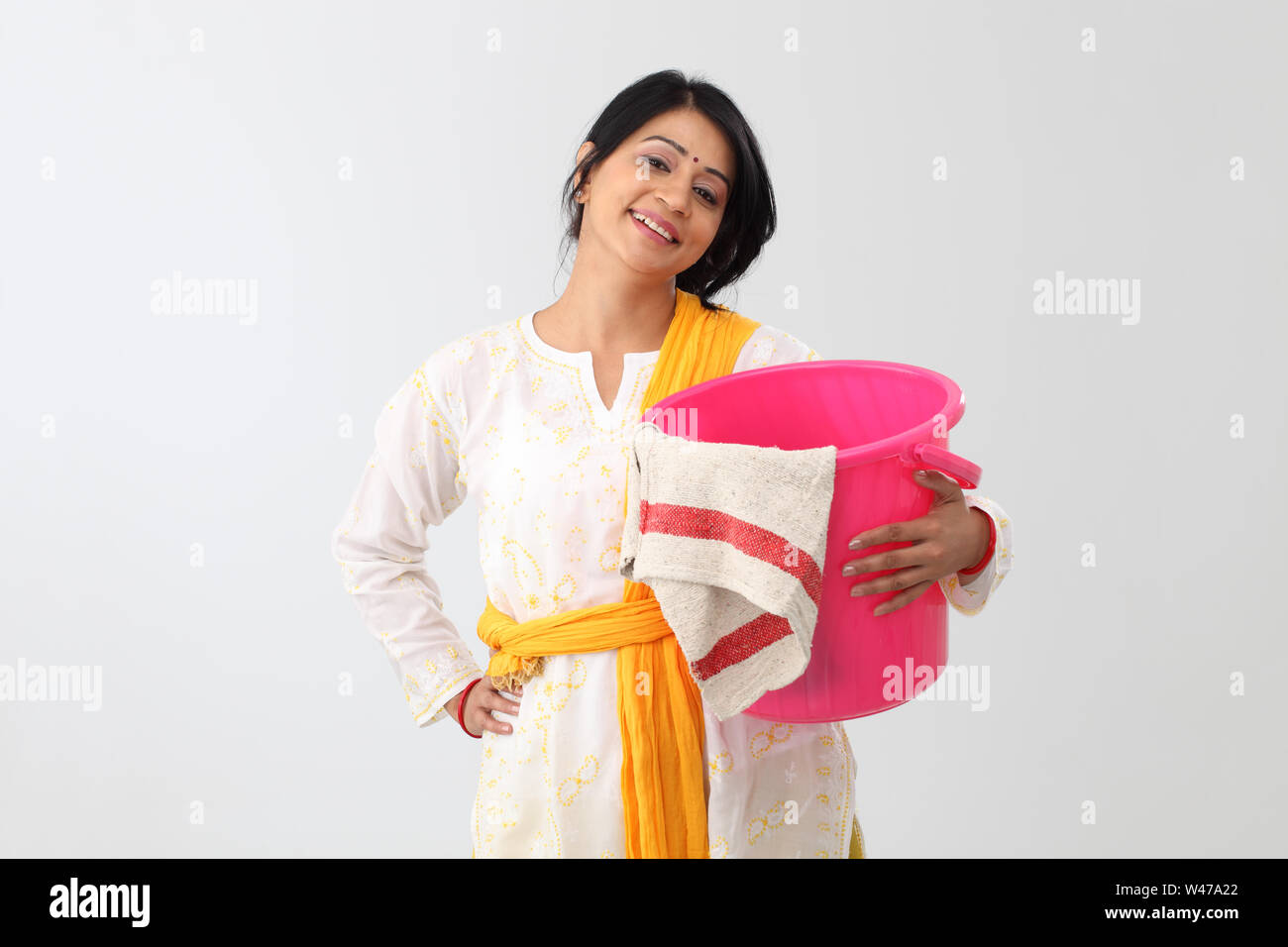 Woman holding a bucket and smiling Stock Photo - Alamy