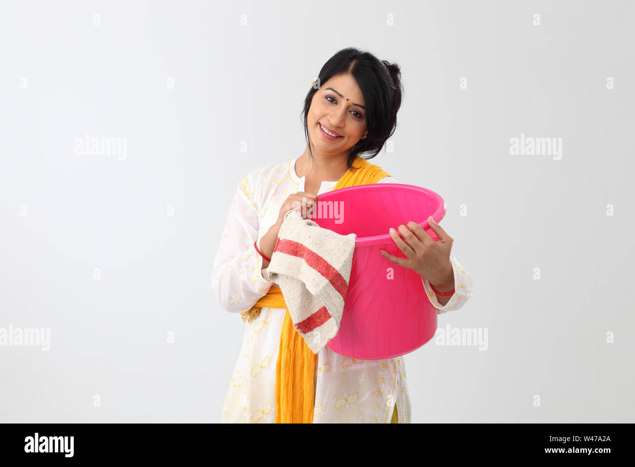 Woman holding a bucket and smiling Stock Photo - Alamy