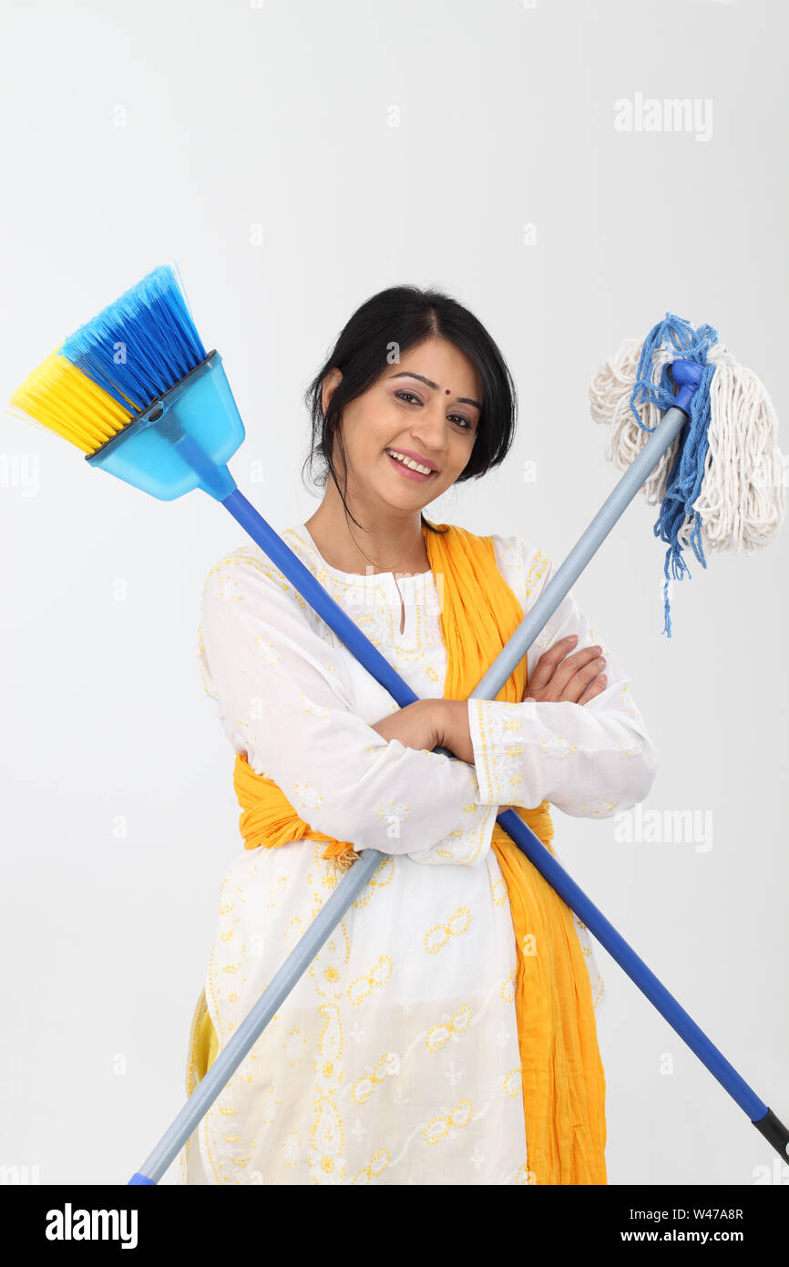 Woman holding mop with broom and smiling Stock Photo - Alamy