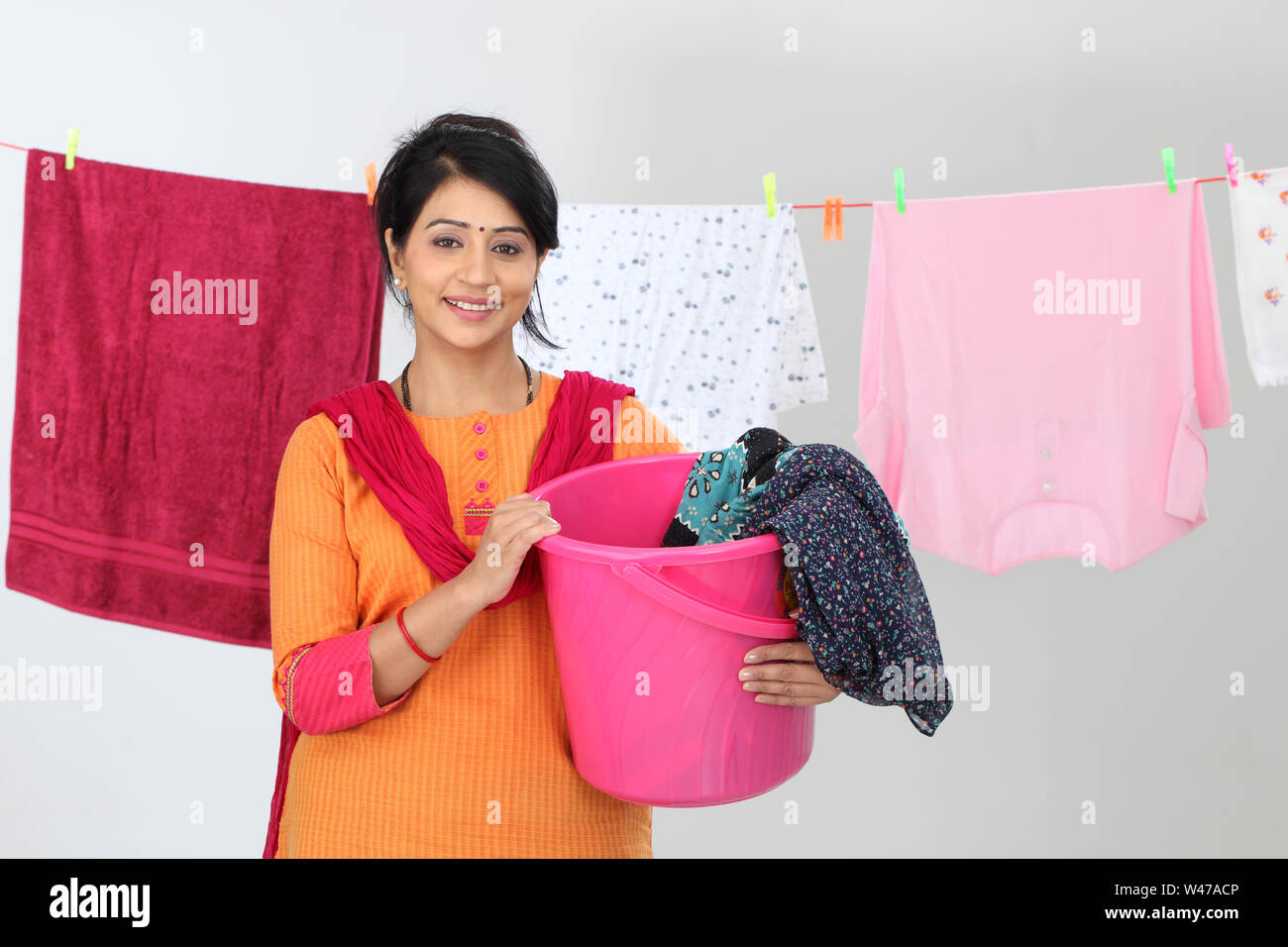 Woman drying clothes and smiling Stock Photo - Alamy