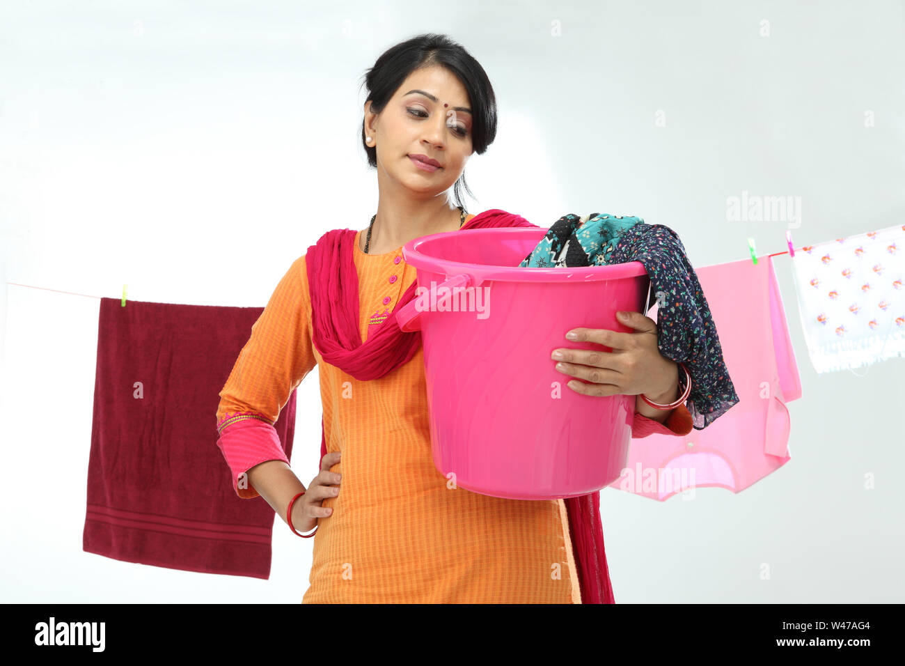 Indian woman looking at bucket Stock Photo - Alamy