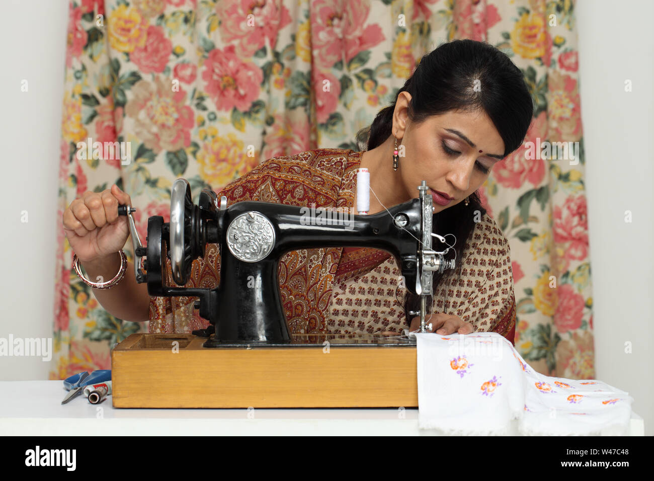 Woman using sewing machine Stock Photo - Alamy