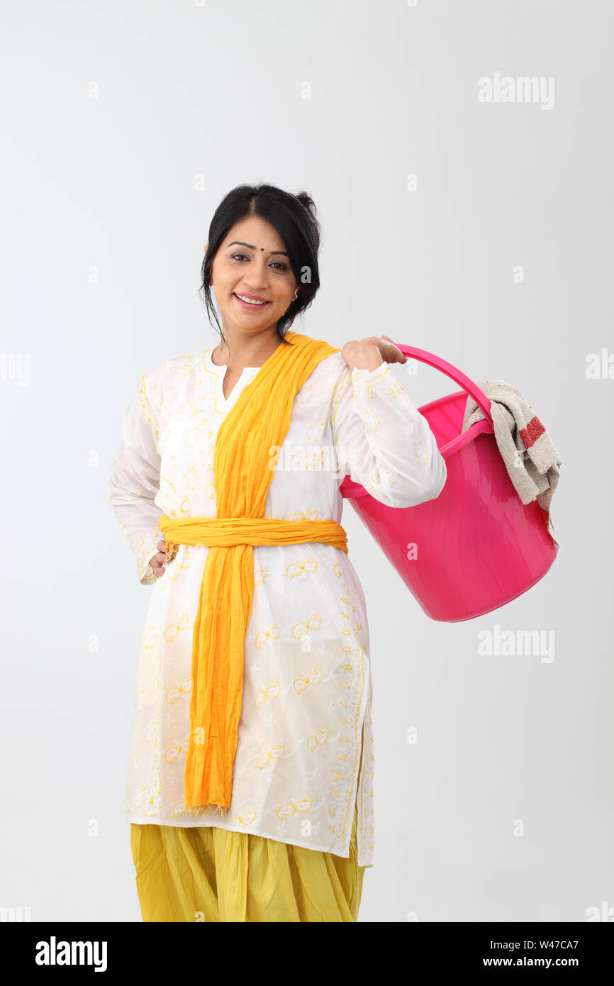 Woman holding a bucket and smiling Stock Photo - Alamy