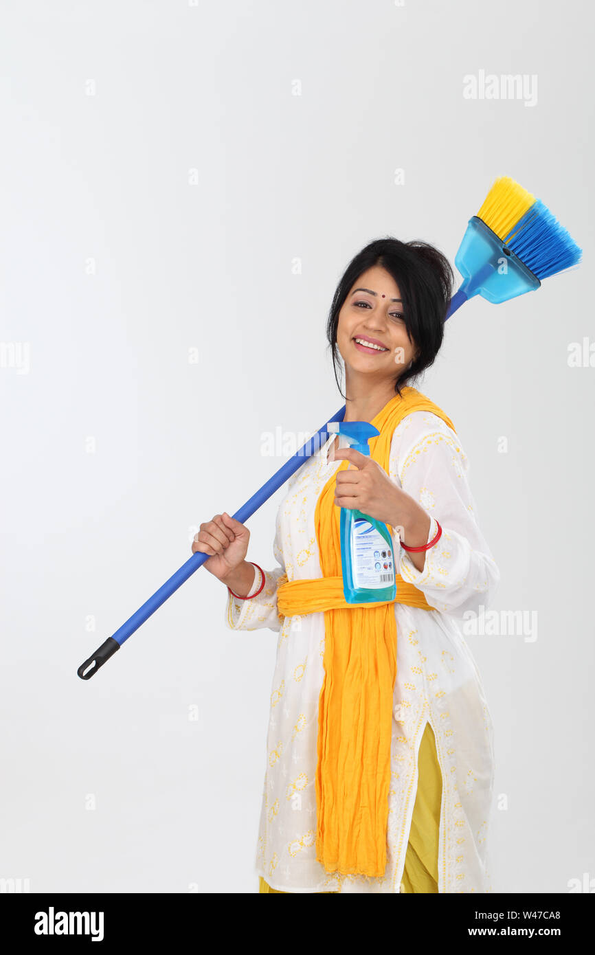 Woman holding broom and spray bottle Stock Photo - Alamy