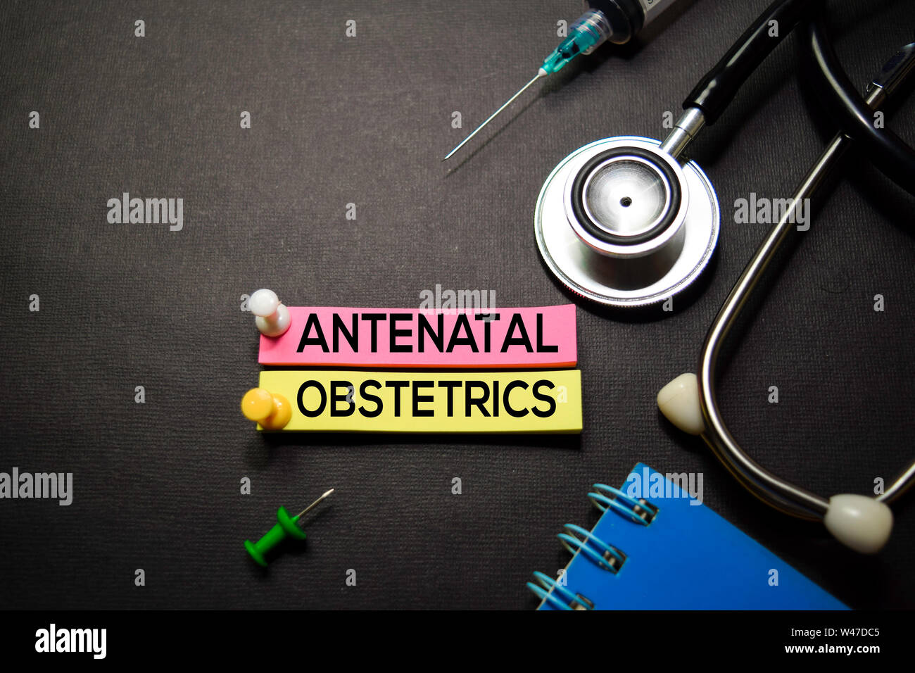 Antenatal Obstetrics text on Sticky Notes. Top view isolated on black ...