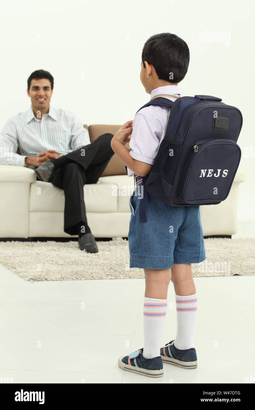 Indian schoolboy looking at his father Stock Photo - Alamy
