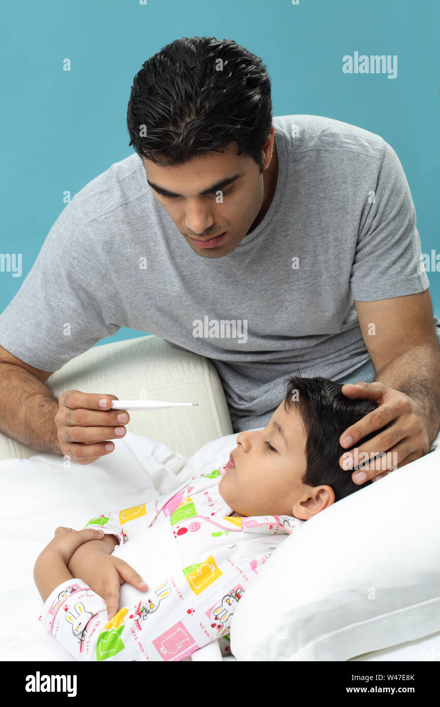 Man checking his son,s temperature Stock Photo - Alamy