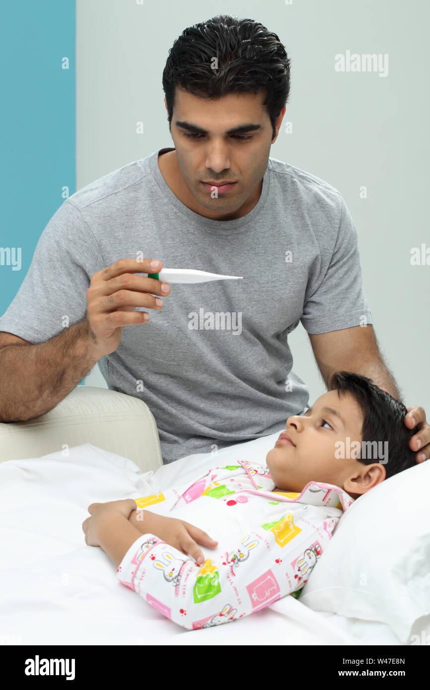 Man checking his son temperature Stock Photo - Alamy