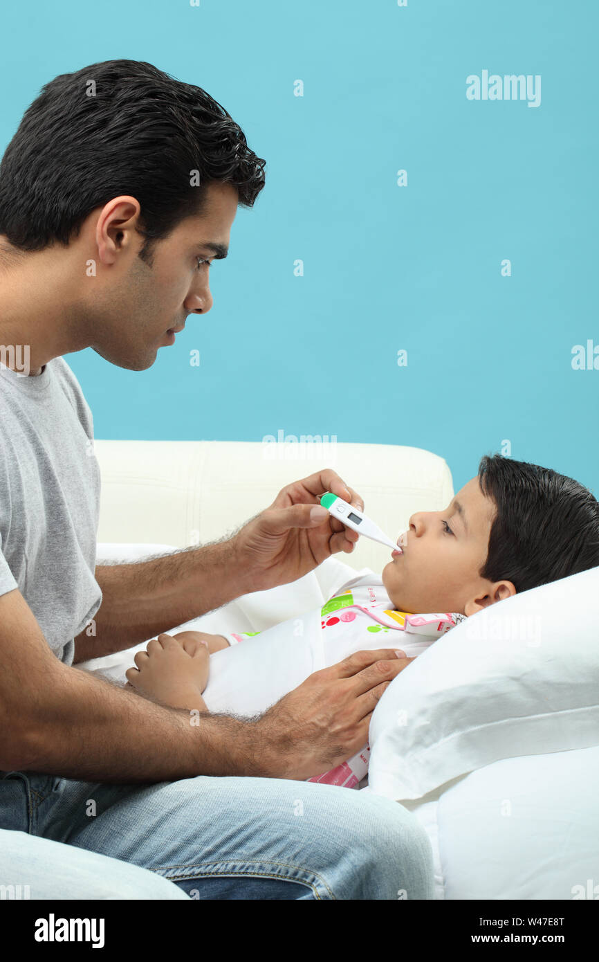 Indian man checking his son temperature Stock Photo - Alamy