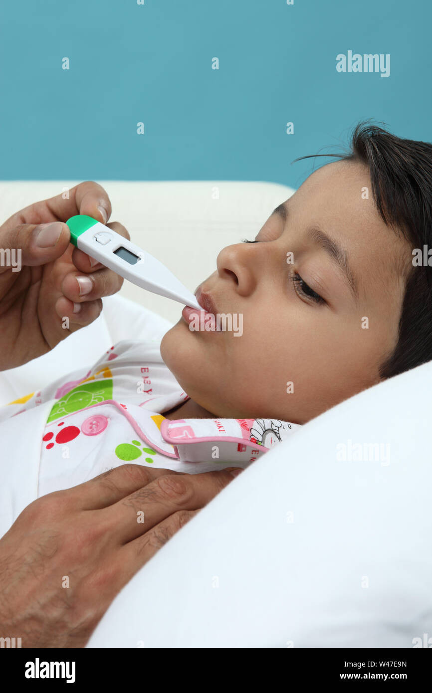 Indian man checking his son temperature Stock Photo - Alamy