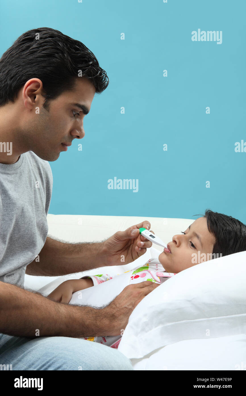 Man checking his son,s temperature Stock Photo - Alamy