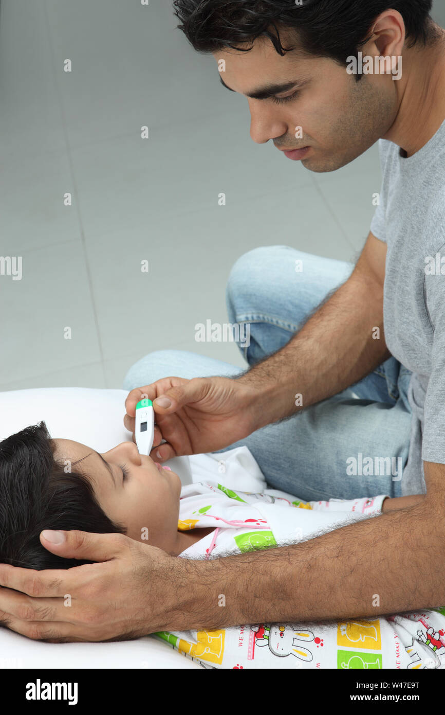 Man checking his son,s temperature Stock Photo - Alamy